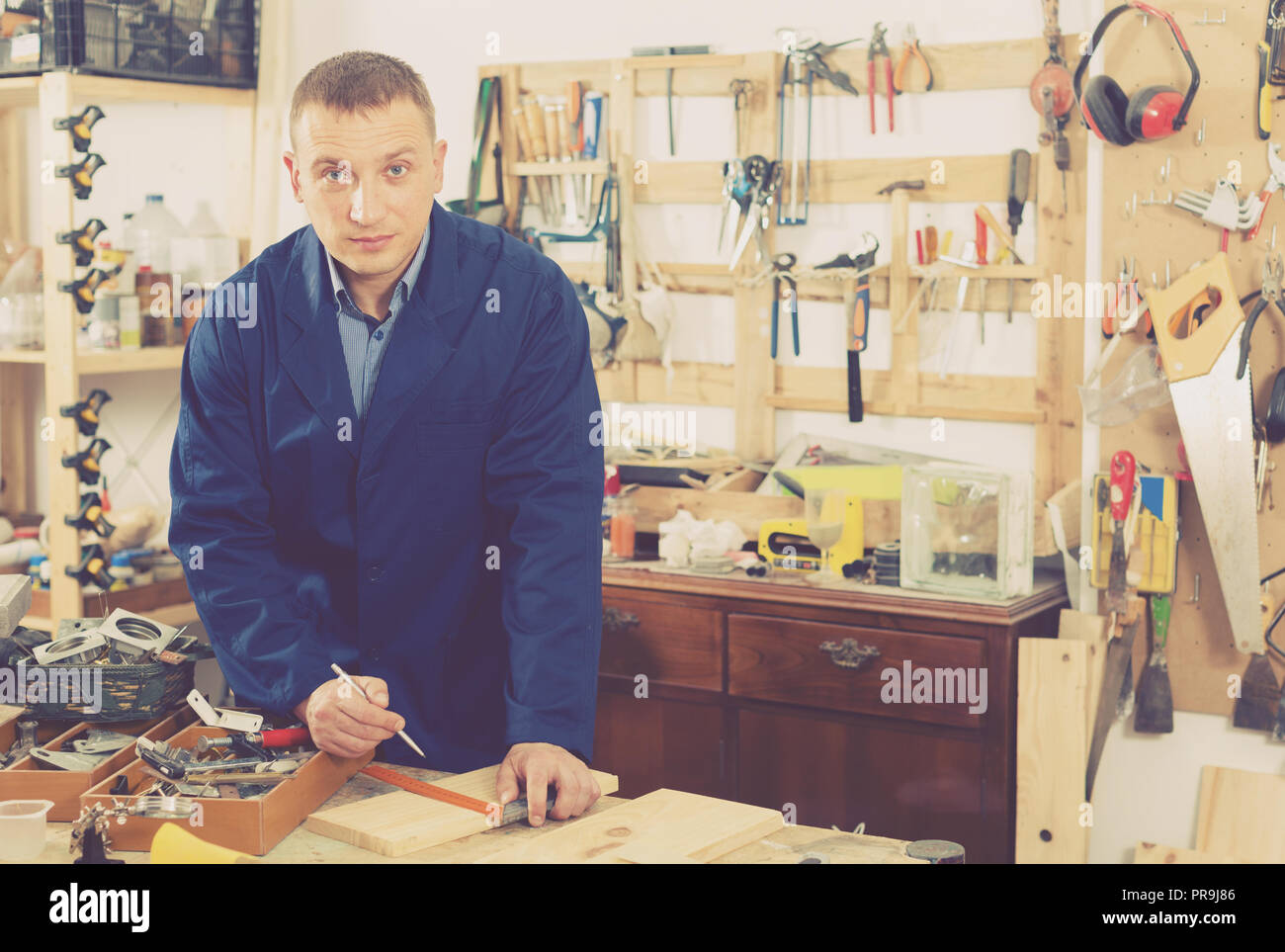 woodwork studio with shelving holding pieces of wood, with a happy ...
