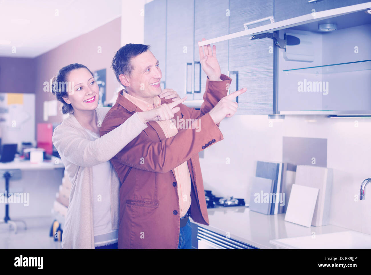 Happy middle class family selecting modern kitchen furniture Stock ...