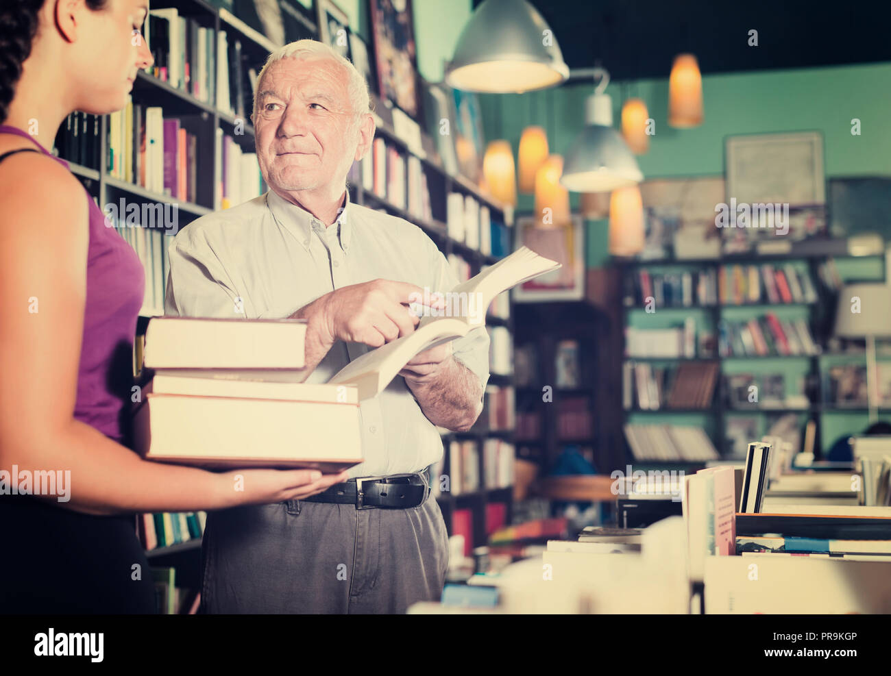 People of different ages read a book in a bookstore Stock Photo - Alamy