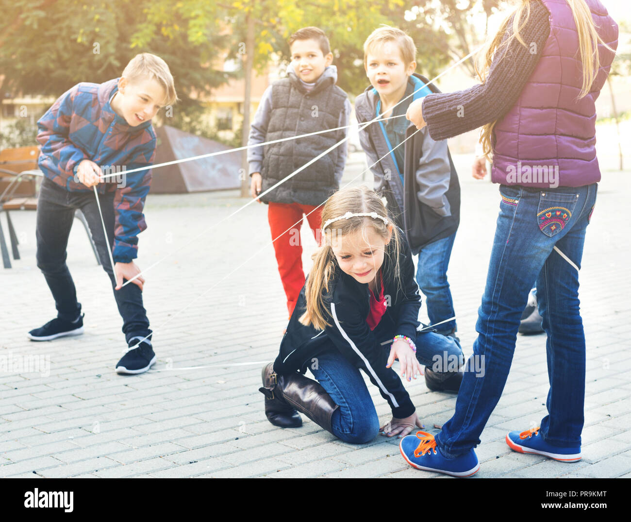 Children games. Smiling happy girl goes through the tangled rope Stock ...