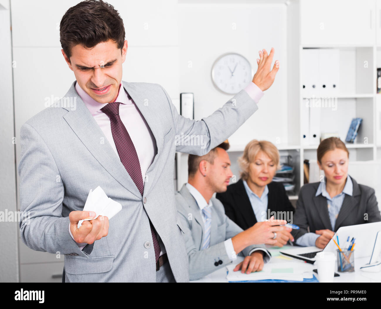 Angry manager standing in office dissatisfied with teamwork of ...