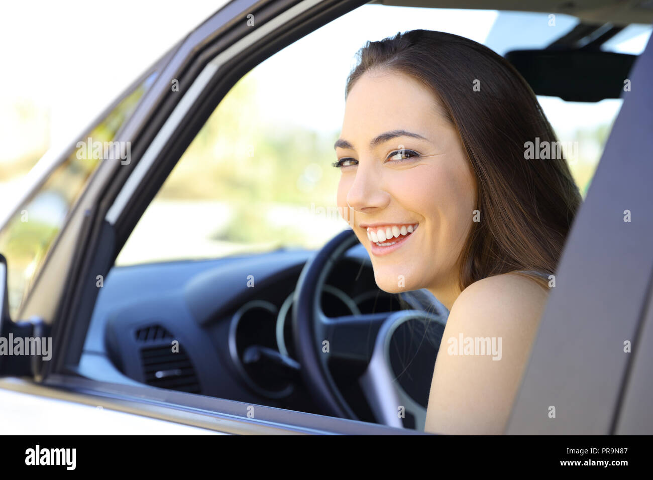 Happy driver looking at camera inside a brand new car Stock Photo - Alamy