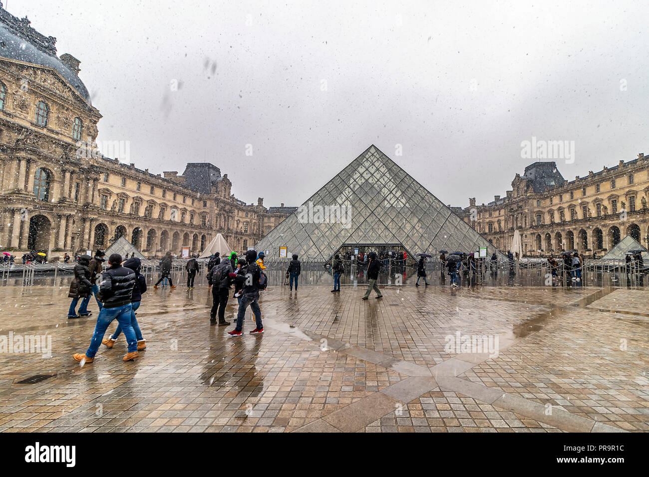 Starting to snow at Louvre museum, Paris, France Stock Photo - Alamy