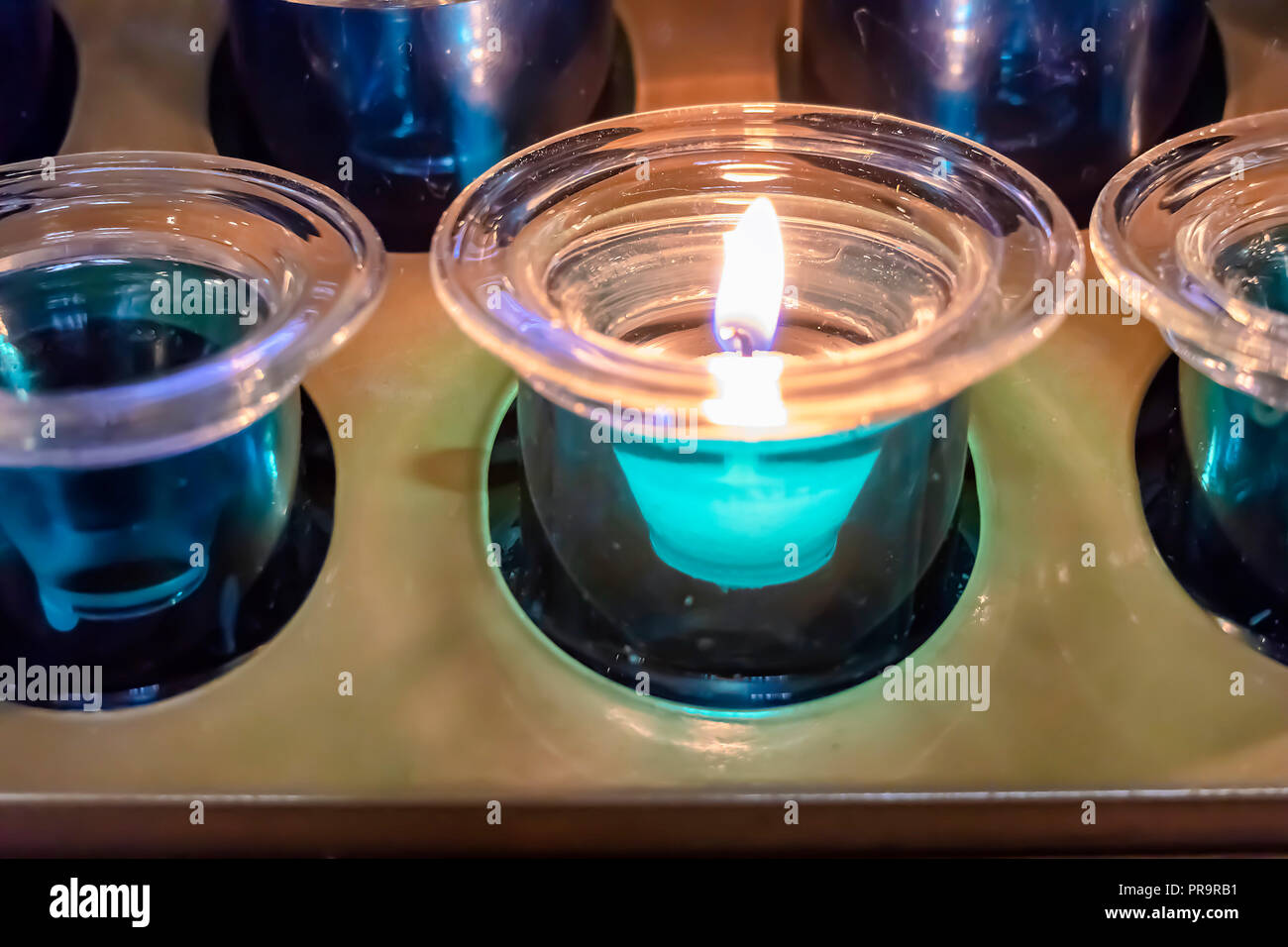 A prayer candle and a flame on a dark background Stock Photo - Alamy