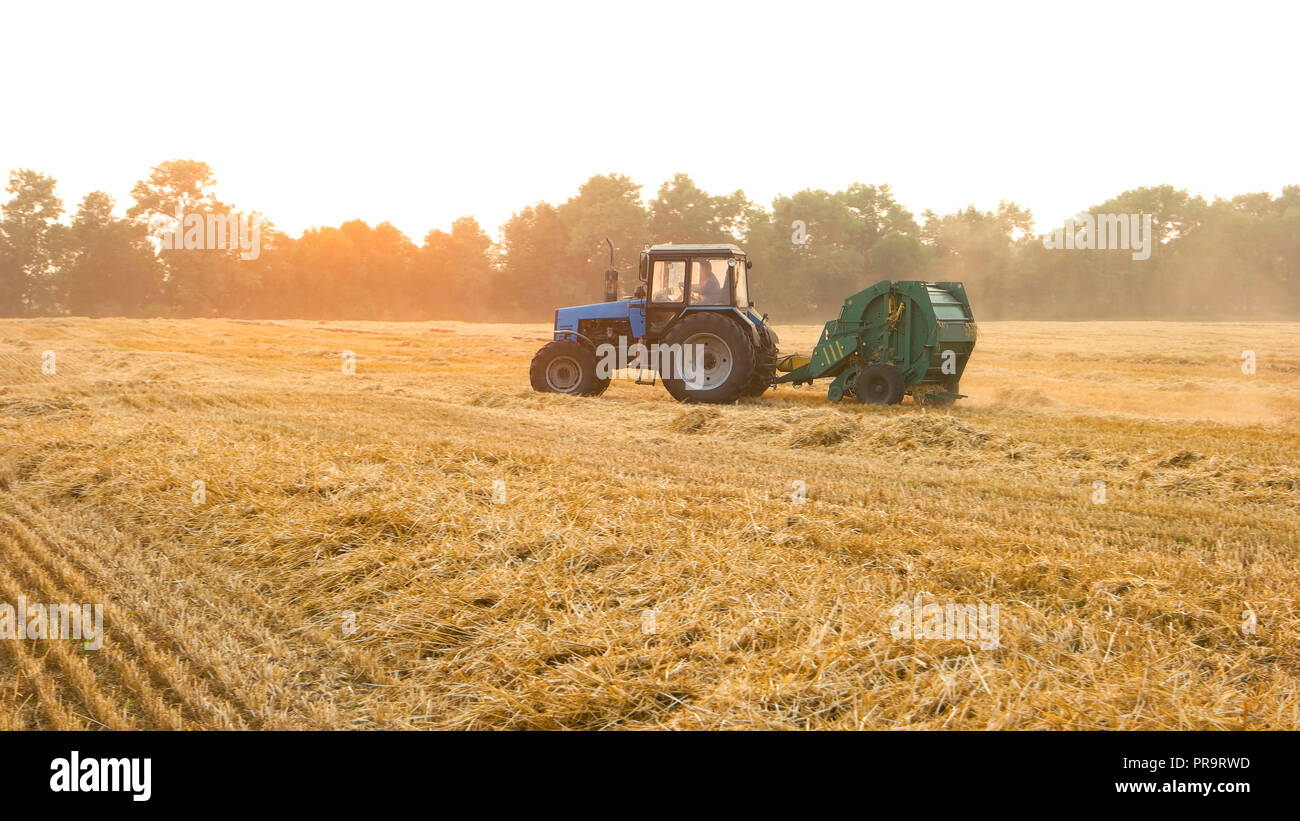 Tractor with hay bale making machine Stock Photo - Alamy