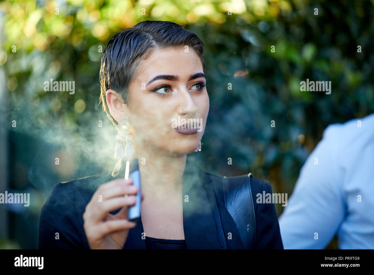 people smoking using vape happing pens in Manchester Stock Photo - Alamy