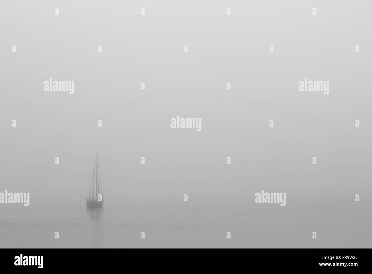 Boat in the sea with a lot of fog Stock Photo - Alamy