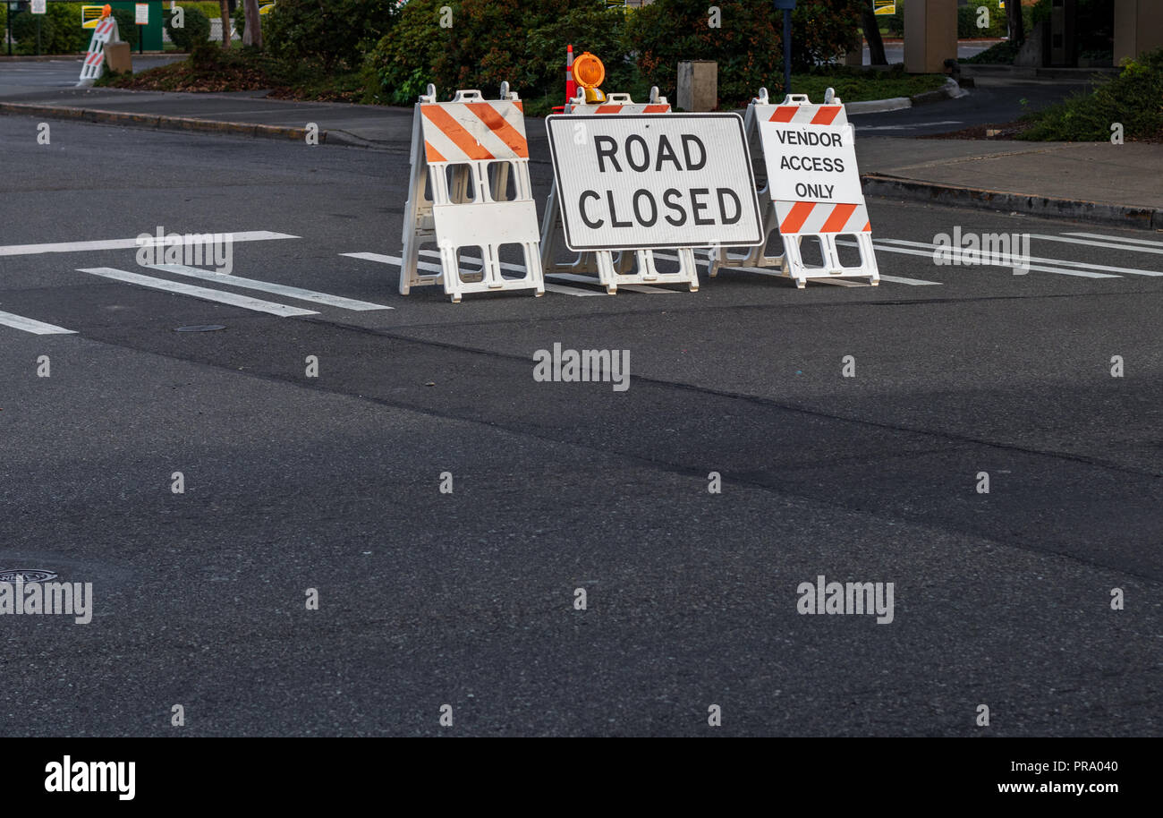 Road closed signs and barricades placed on a crosswalk at an ...
