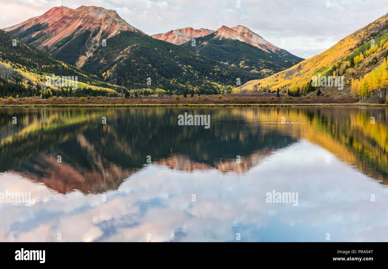 Pink clouds reflected in Crystal Lake below the Red Mountains in Autumn ...