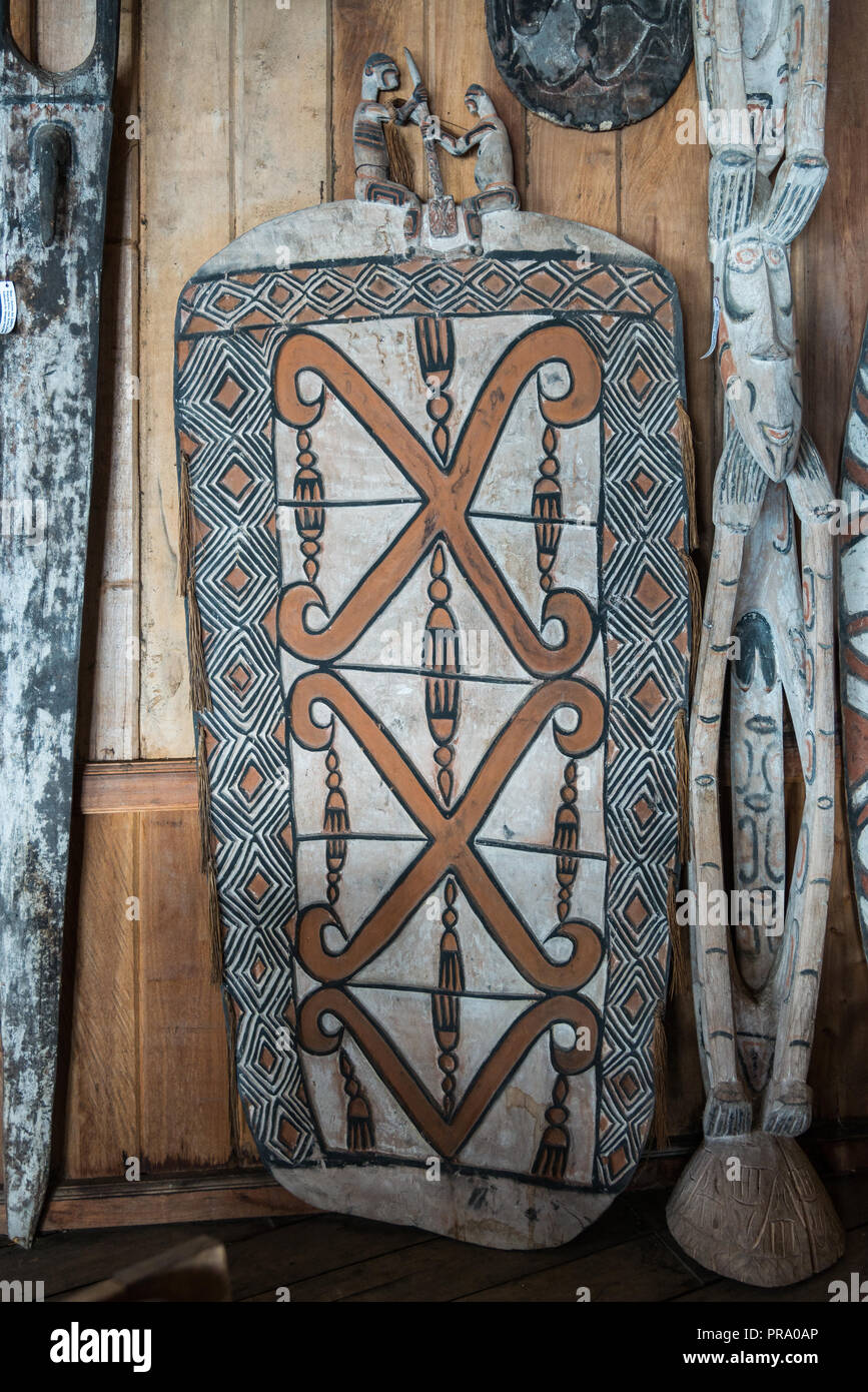 A colorfully painted war shield and other native artifacts. Wamena ...