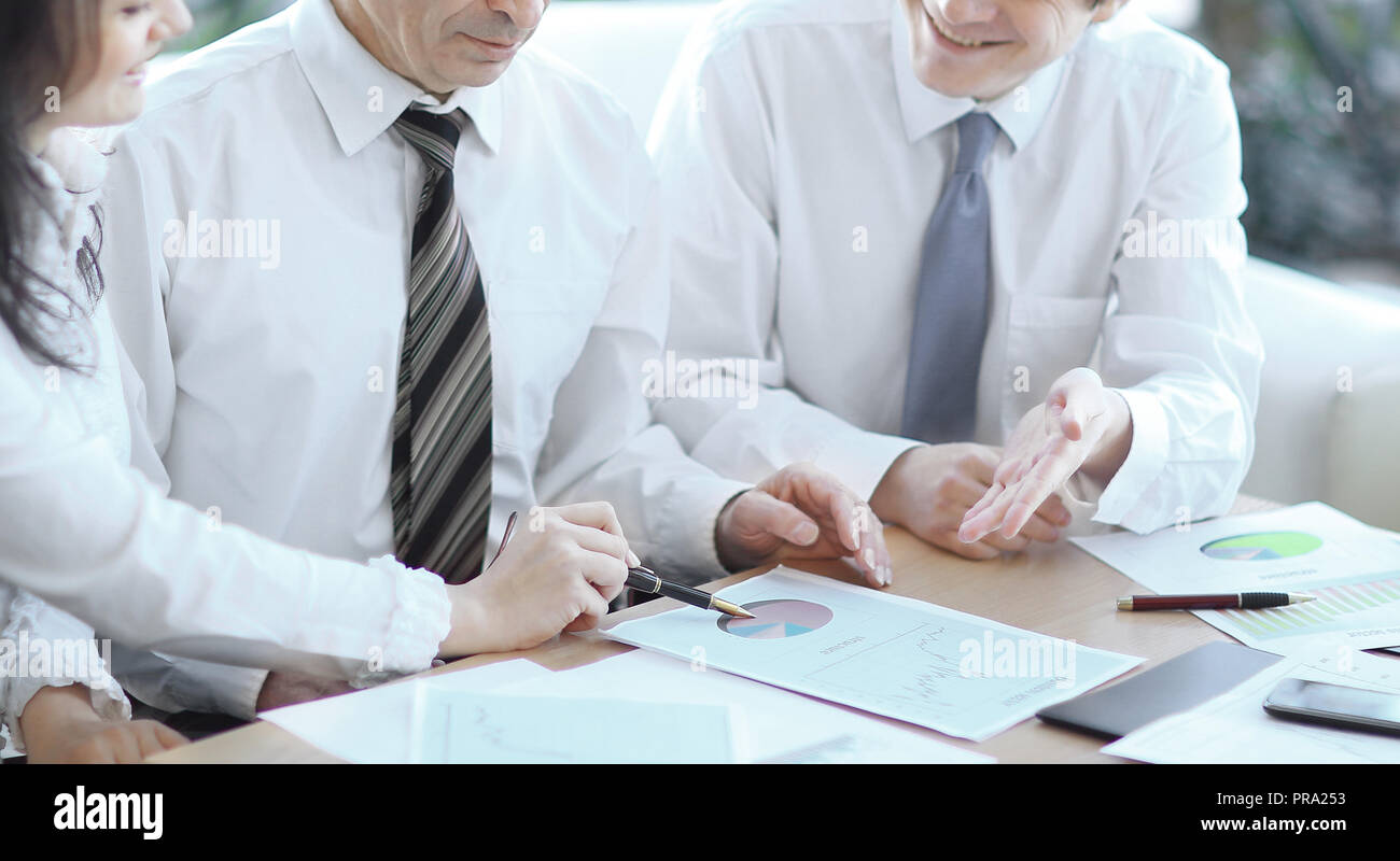 Business people working together and analyzing financial figures on a ...