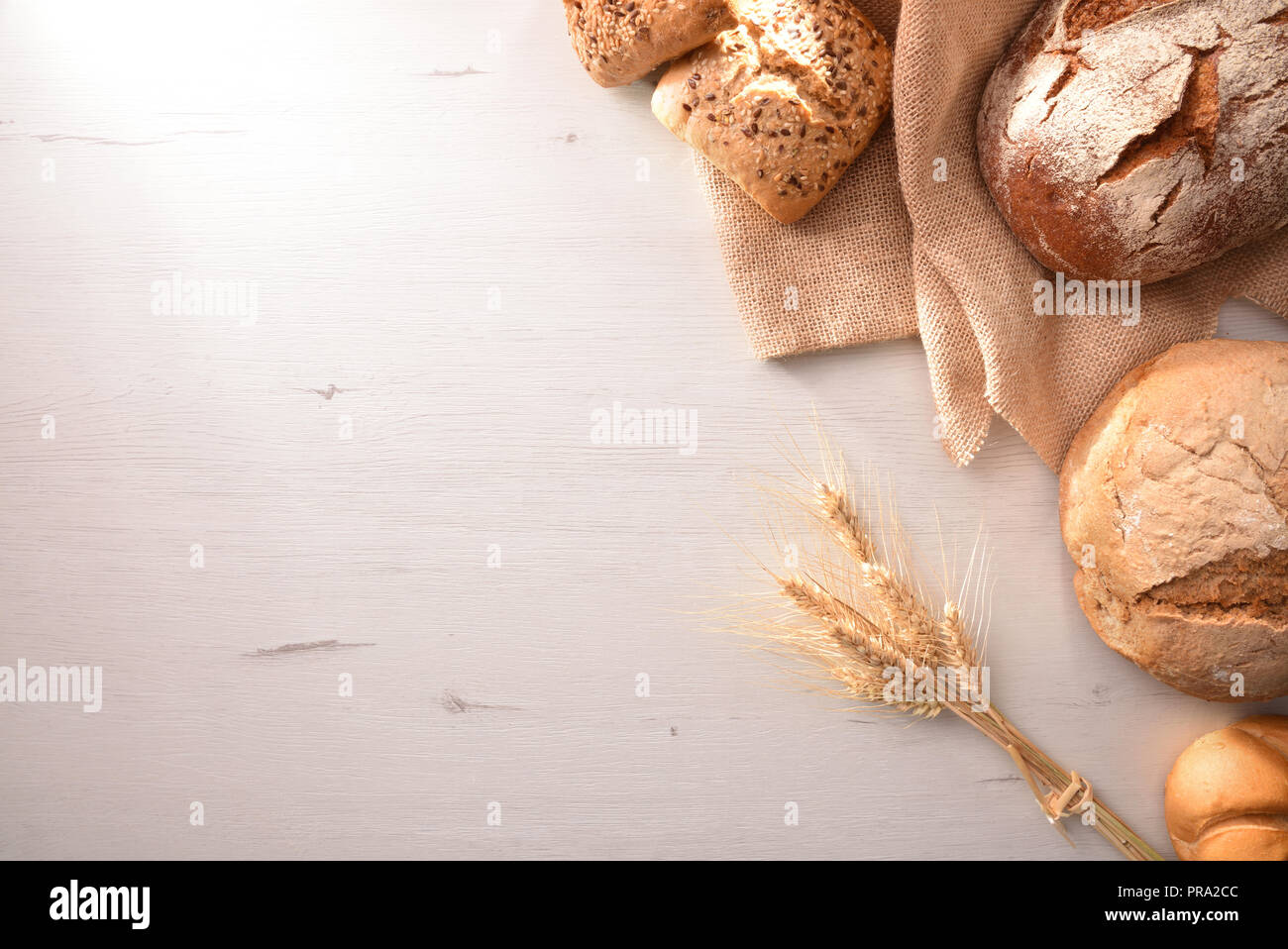 Selection of breads on a white table decorated with wheat branches and ...