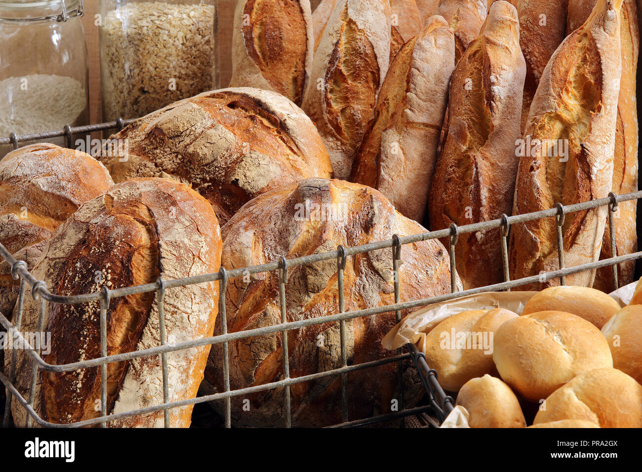 Different types of bread and buns in a metal basket on a wooden ...