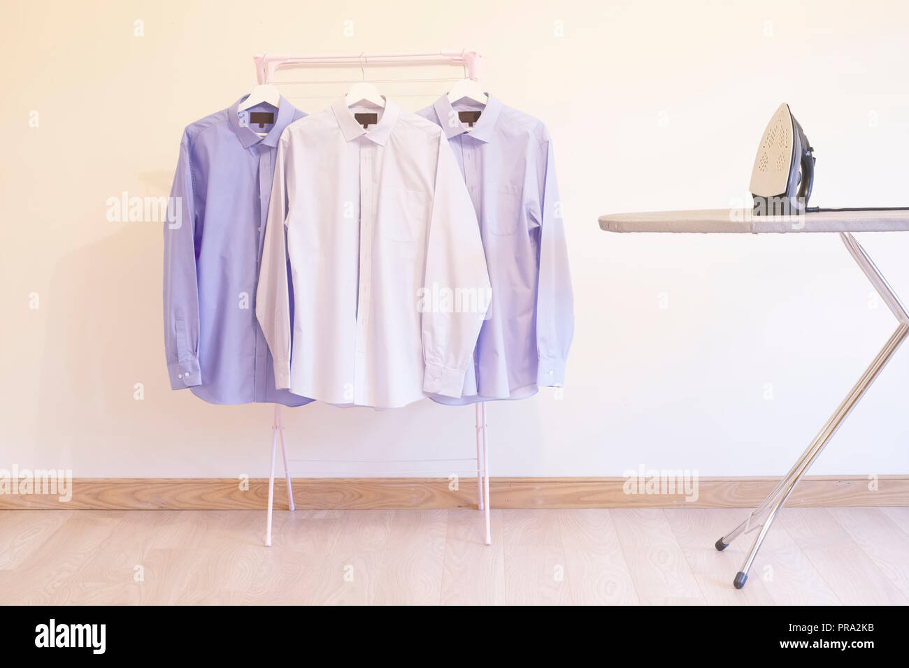 Washing shirts hanging up to dry and iron board indoor wooden interior ...