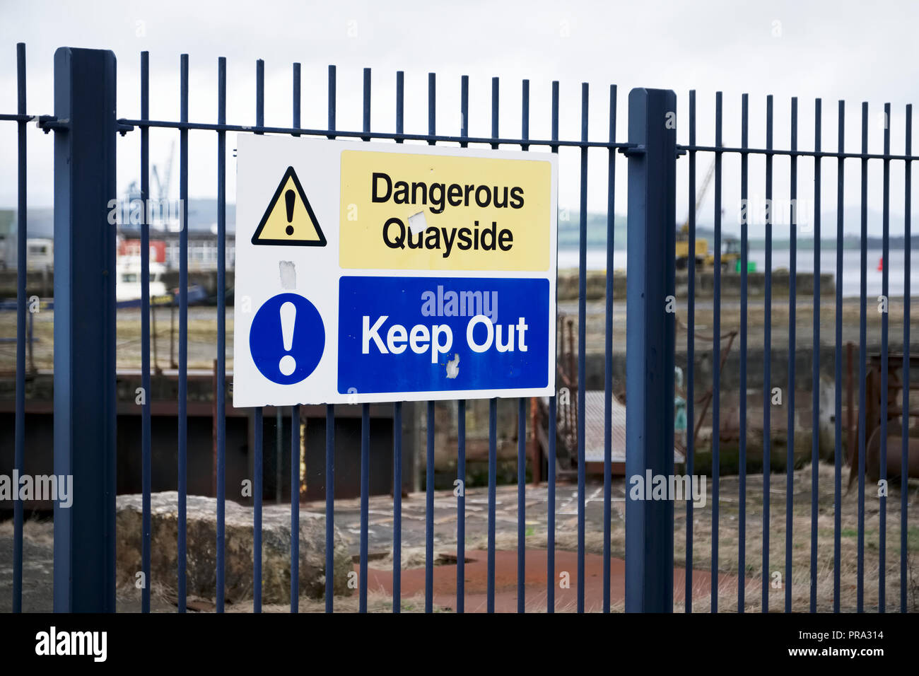 Dangerous quayside keep out sign on fence at sea water harbour dock ...
