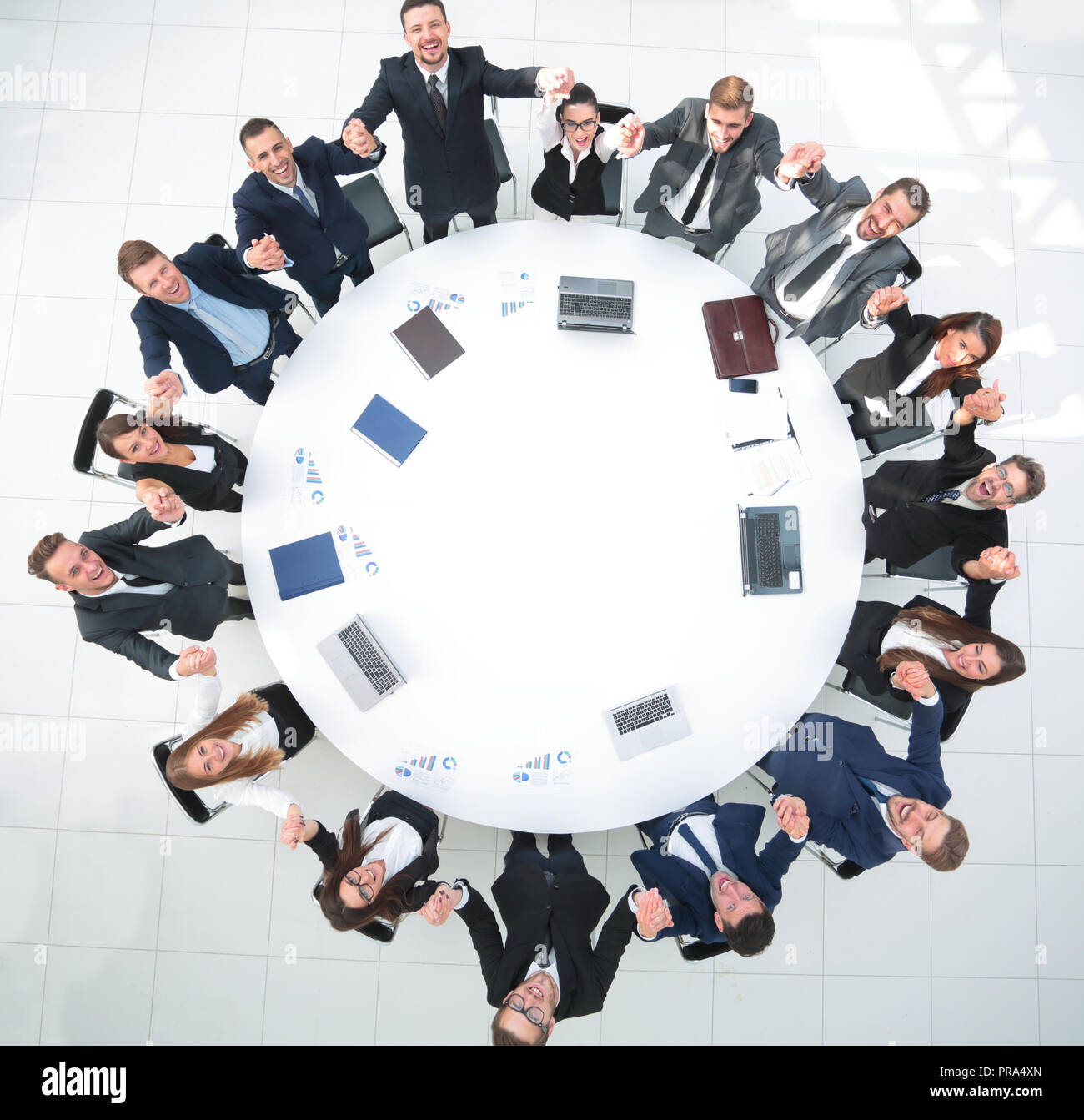 large business team sitting at the round table and raising his hands up ...