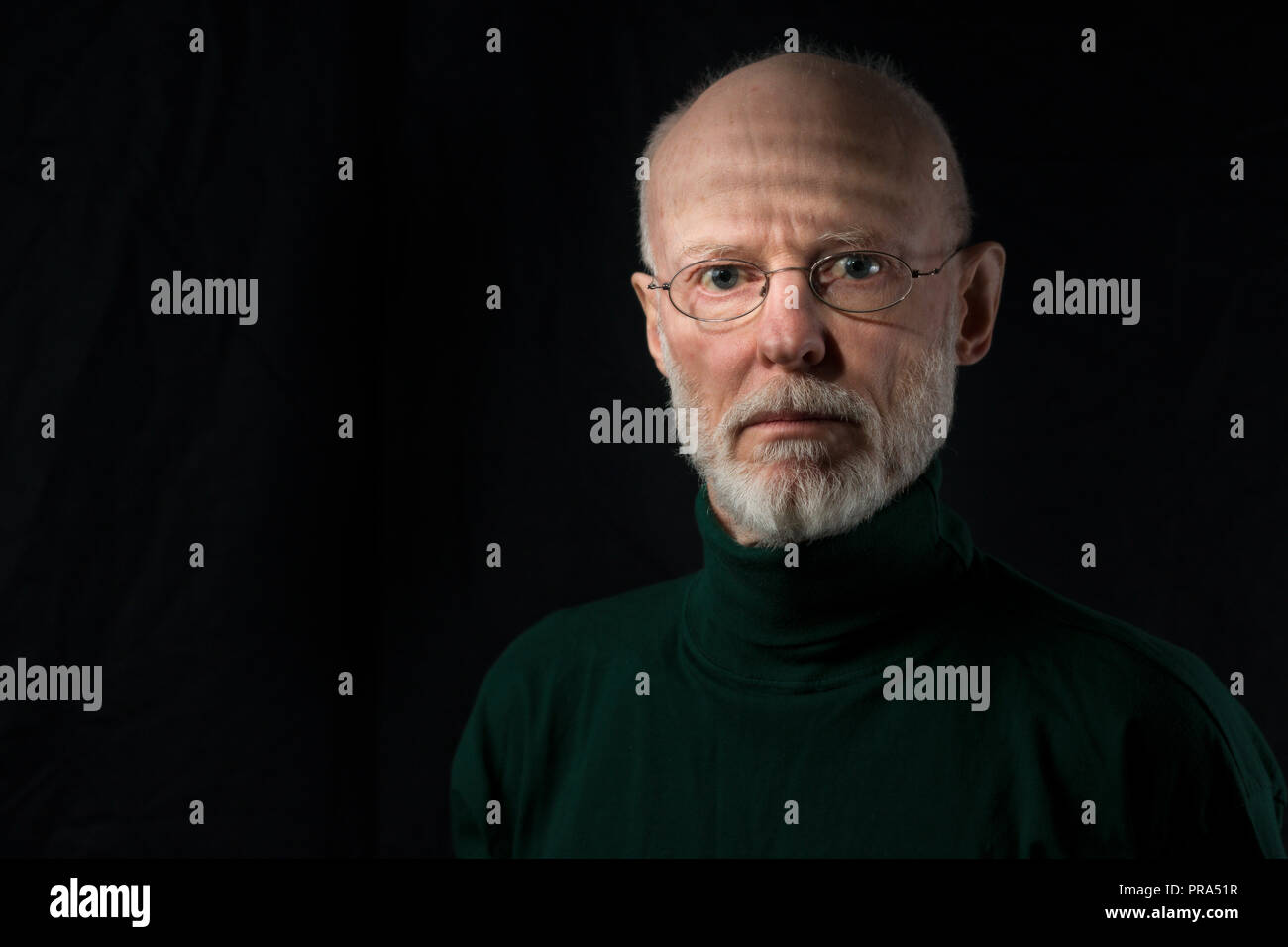 portrait of serious questioning senior man on black background Stock ...