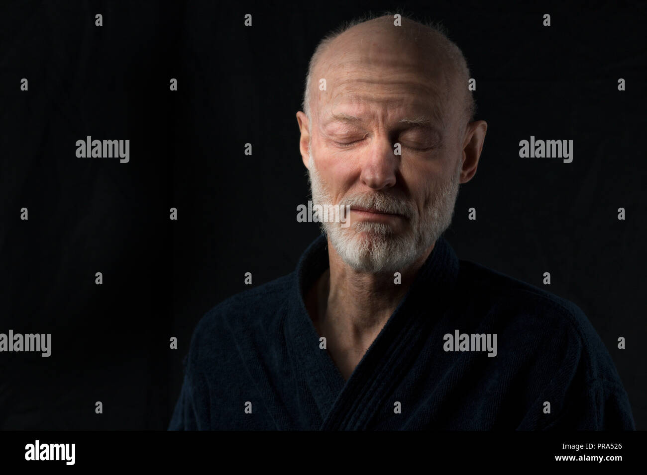 portrait of sleepy senior man in bathrobe on black background Stock ...