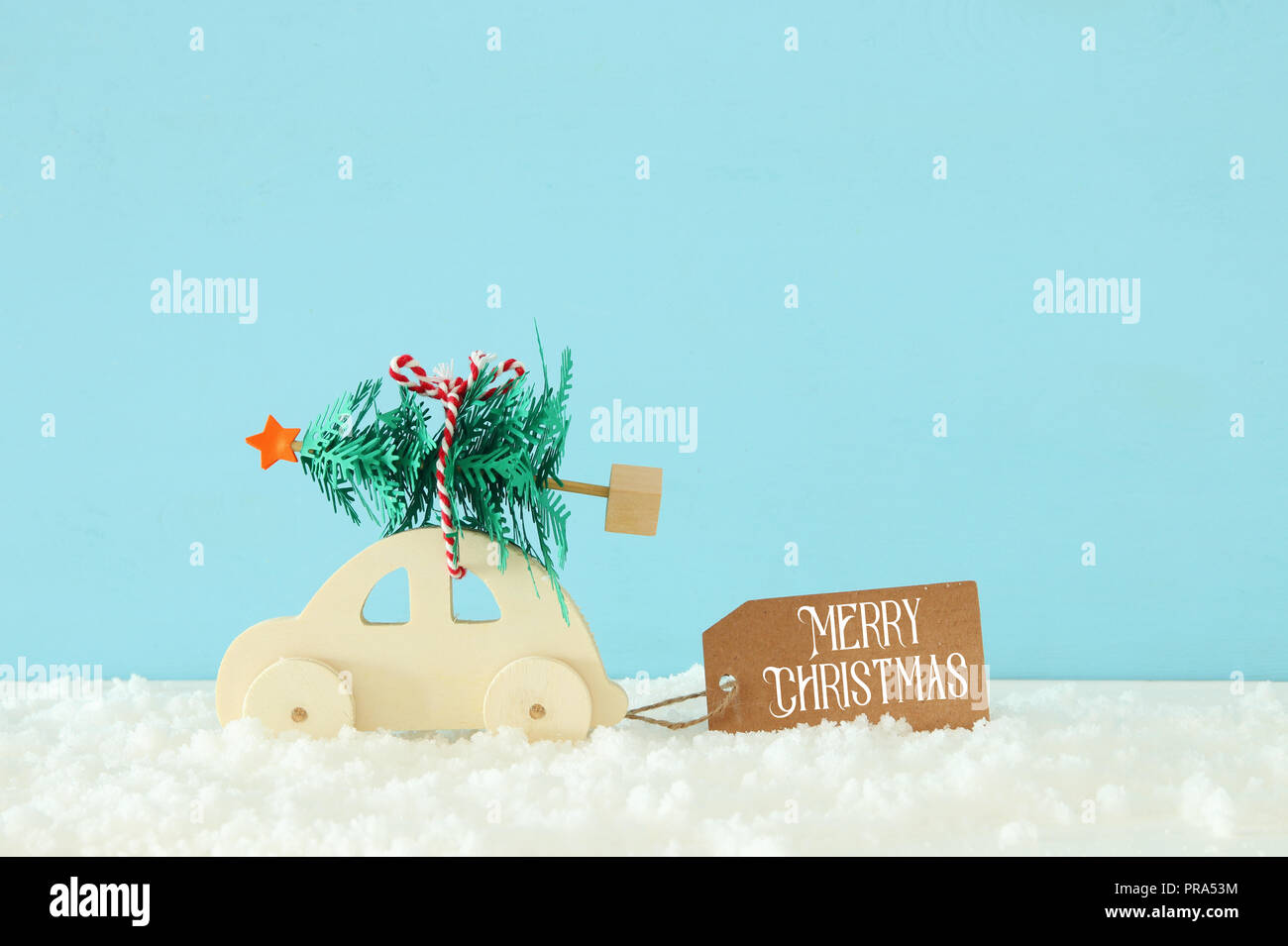 Wooden car carrying a christmas tree in front of blue background Stock ...
