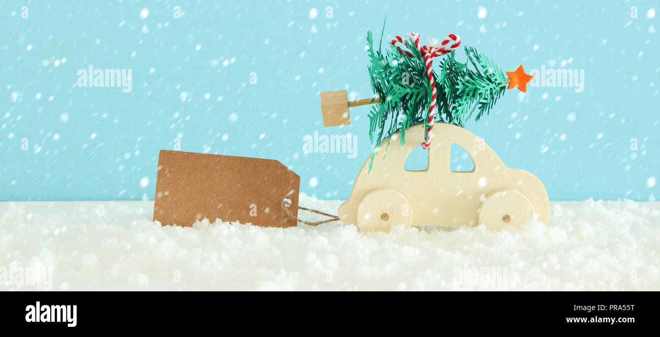 Wooden car carrying a christmas tree in front of blue background Stock ...