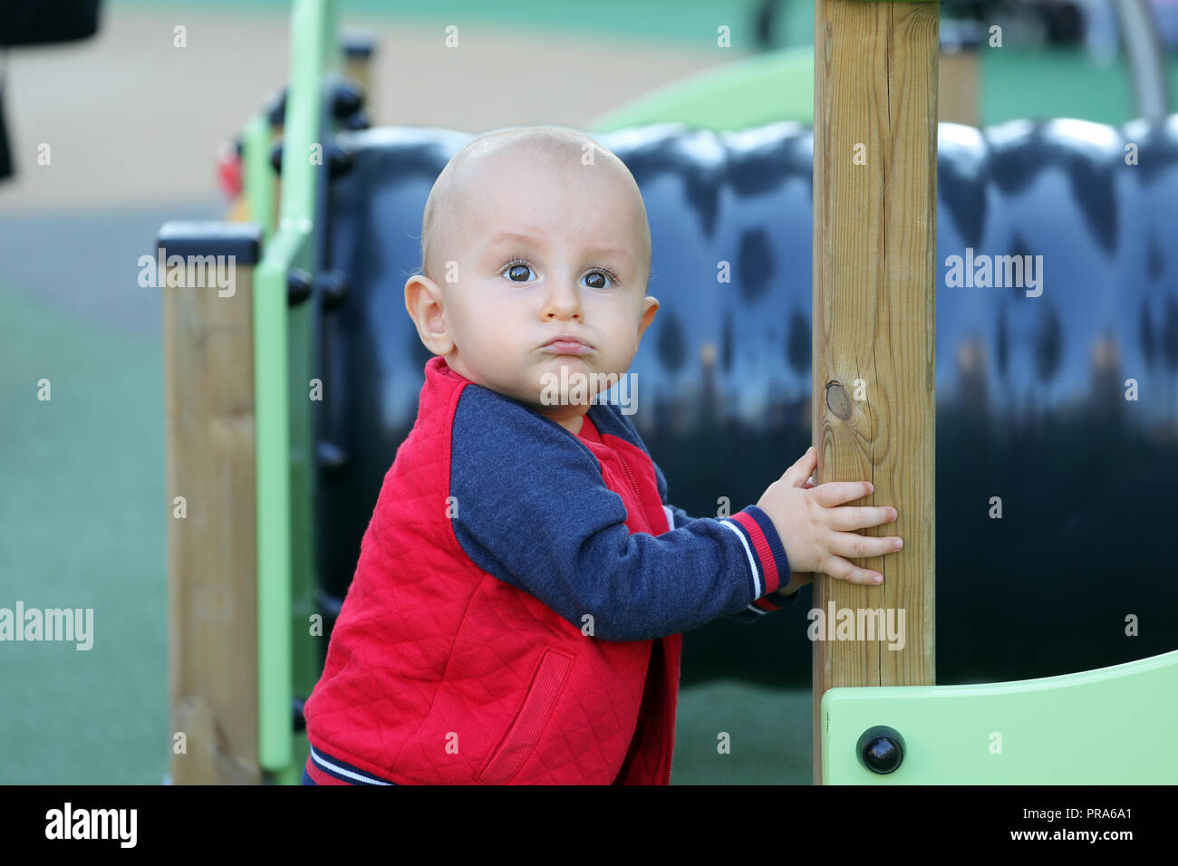 Cute Baby Boy Learning To Stand At The Outdoor Playground. Close Up ...