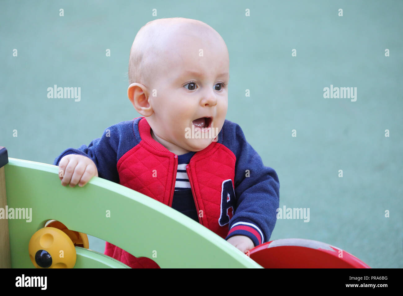 Cute Baby Boy Learning To Stand At The Outdoor Playground. Close Up ...