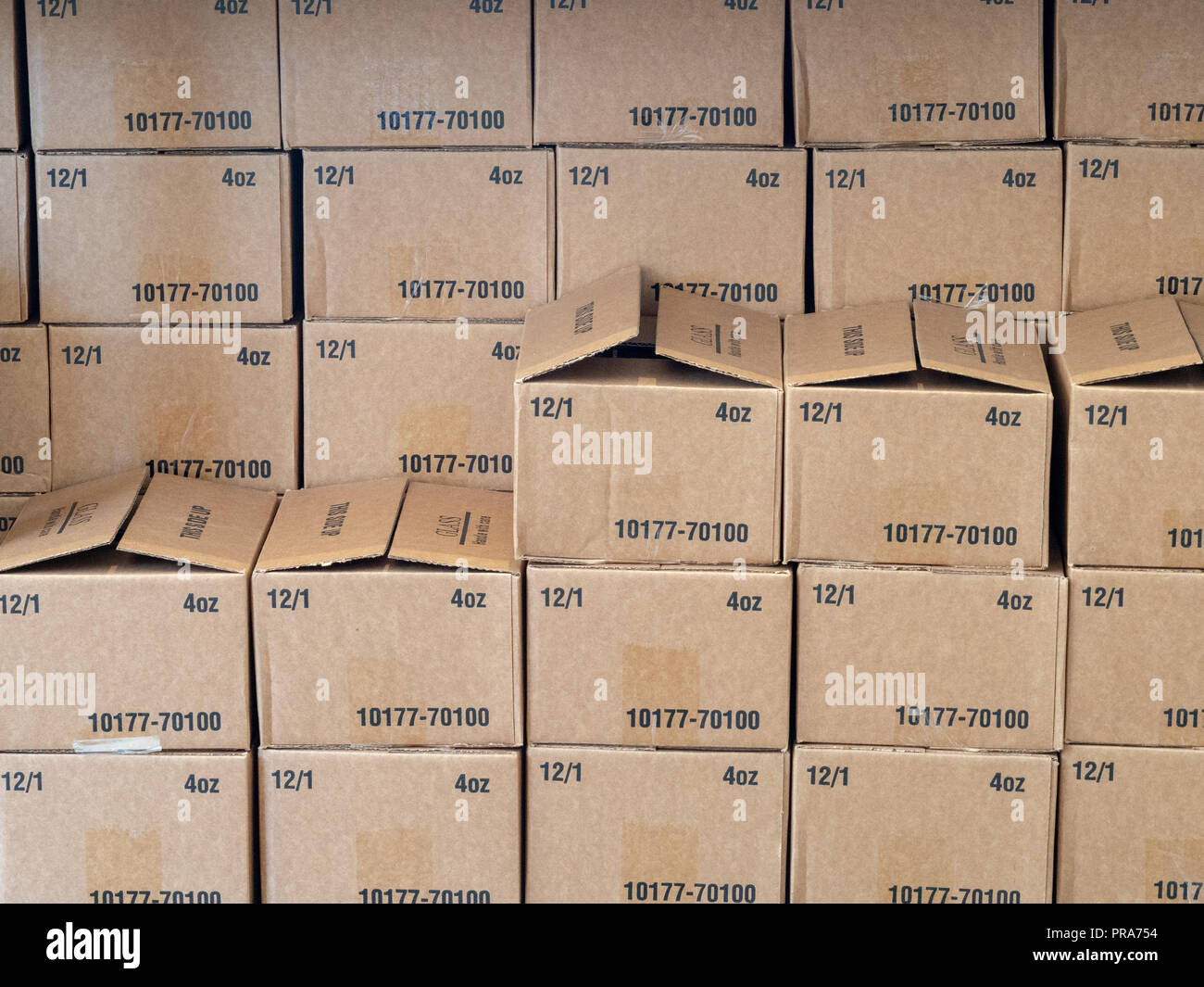 Rows and stacks of cardboard boxes sitting inside a warehouse Stock ...