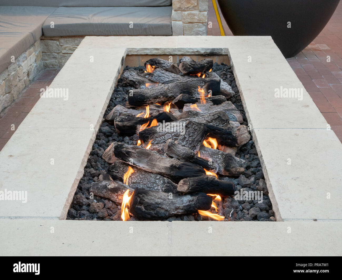 Long, rectangular fire pit sitting in open air plaza Stock Photo - Alamy