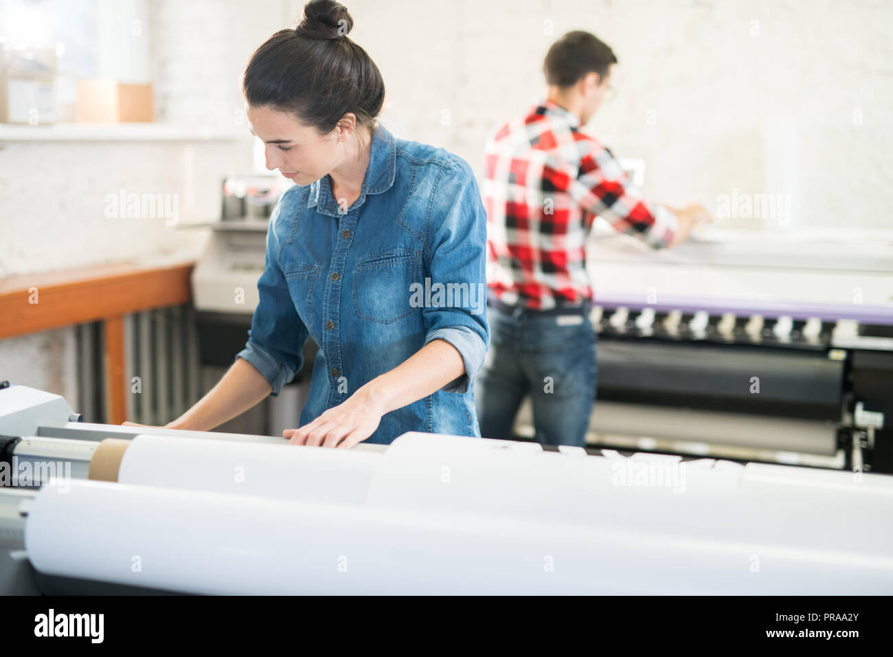 Concentrated woman working in printing office Stock Photo - Alamy