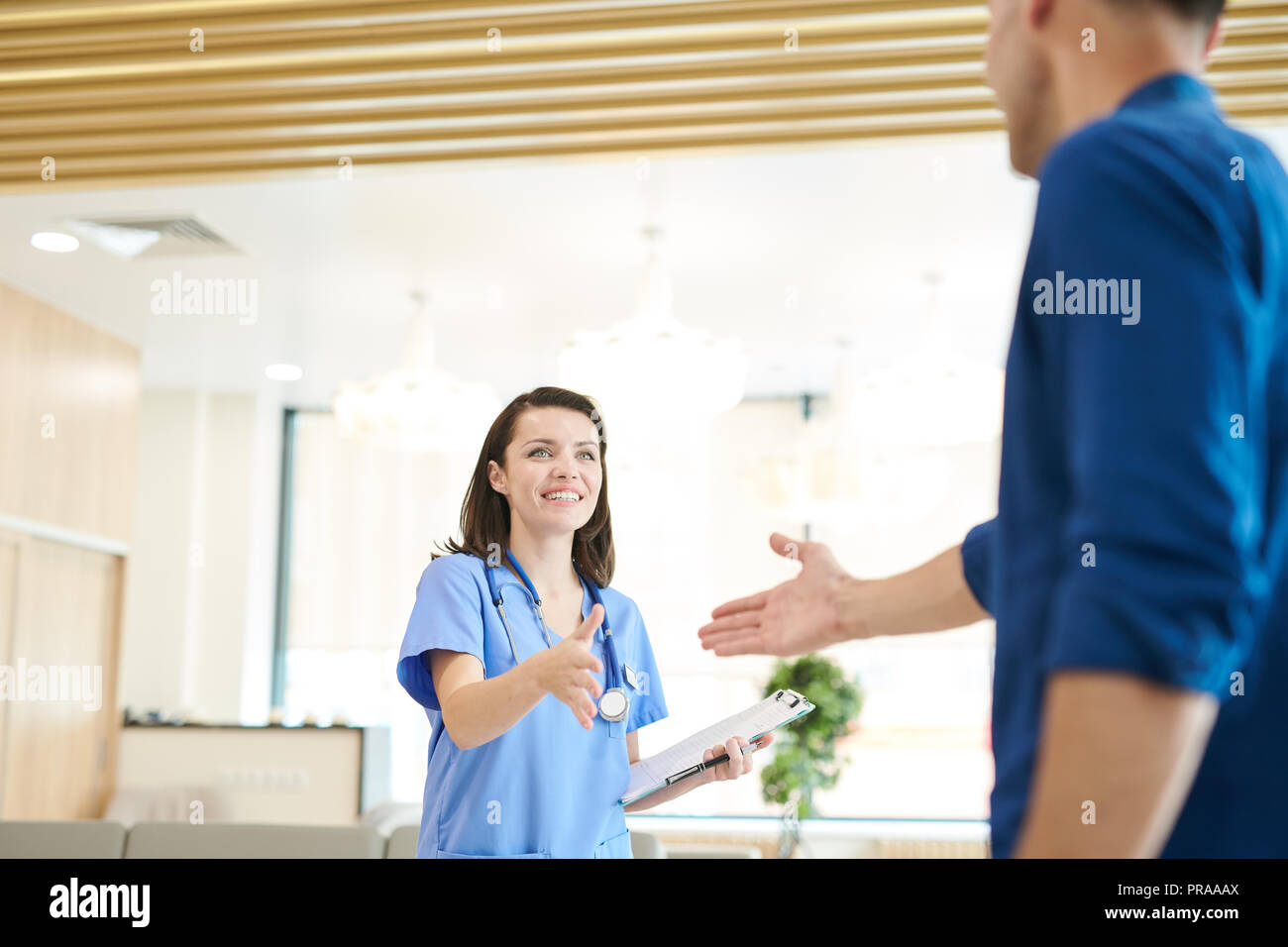 Cheerful Nurse Greeting Patient Stock Photo - Alamy