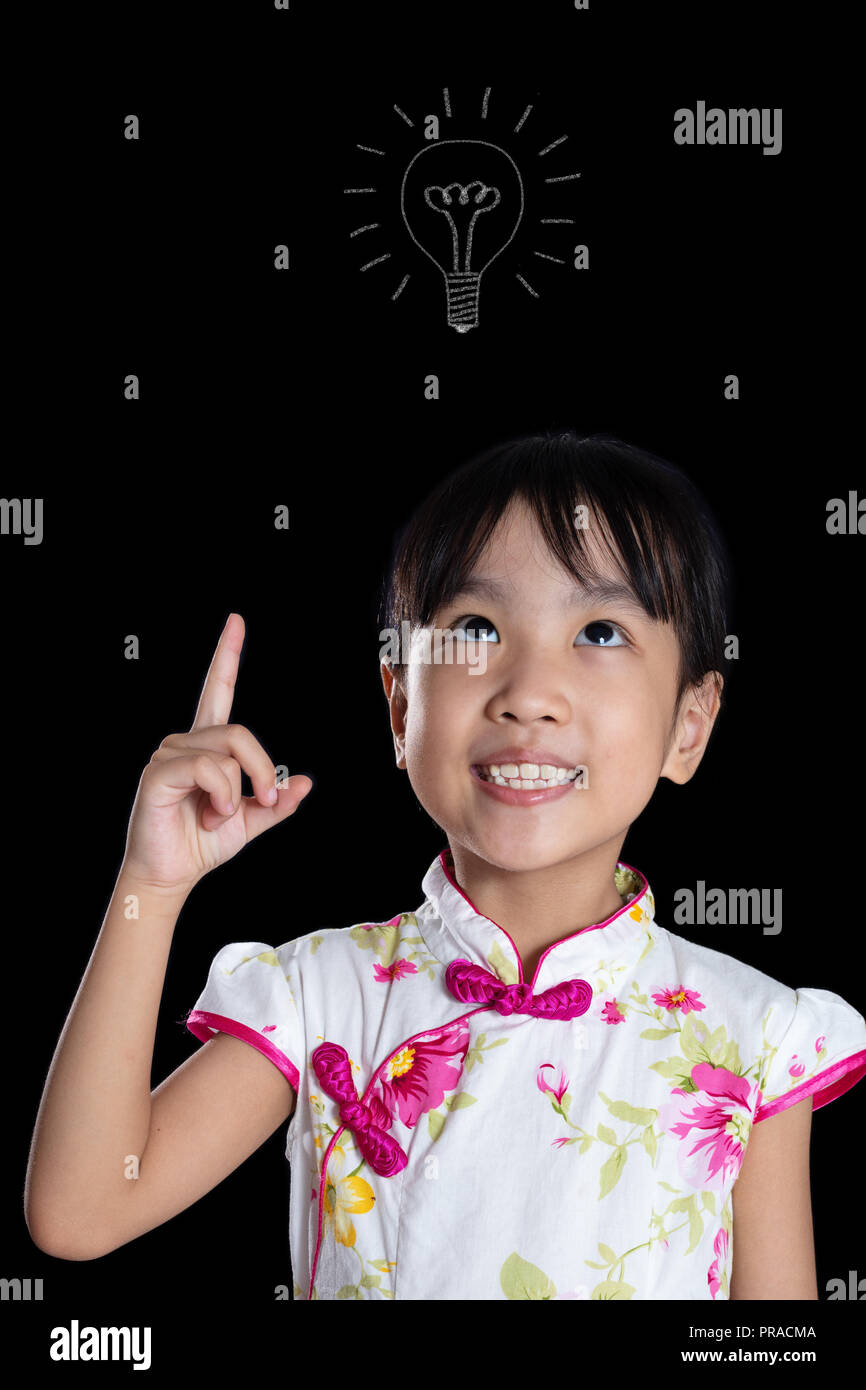 Asian chinese little girl pointing finger up to bulb in isolated black ...