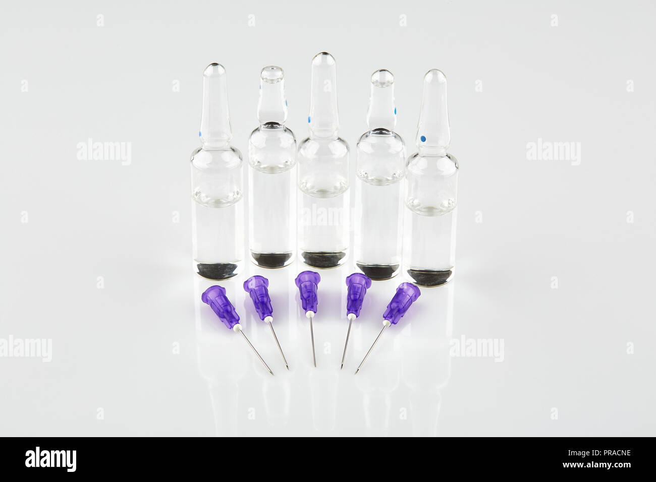 Ampoules and violet syringe needles on white background Stock Photo - Alamy