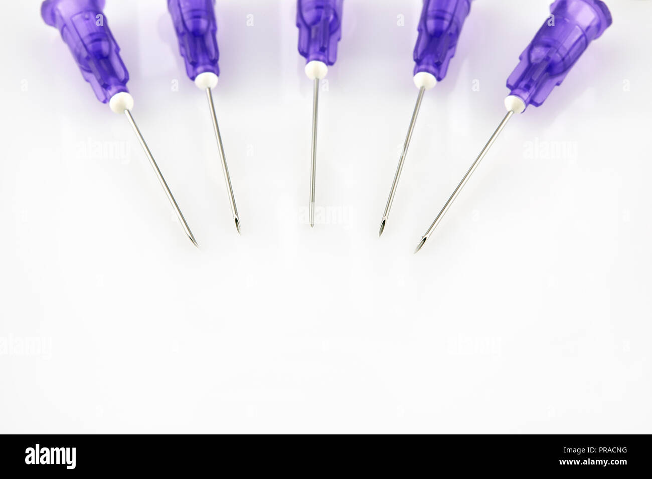 Five violet syringe needles on white background Stock Photo - Alamy