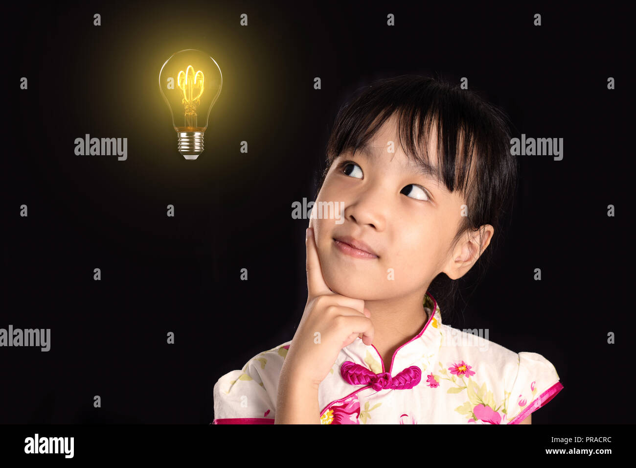 Asian Chinese little girl thinking with light bulb in isolated black ...