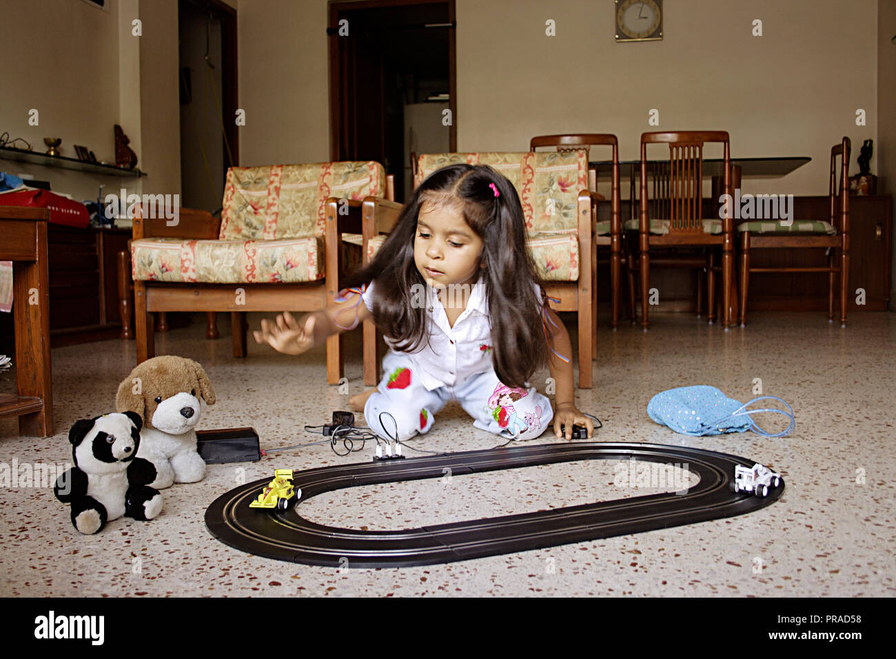 Young girl playing with racing cars Stock Photo - Alamy