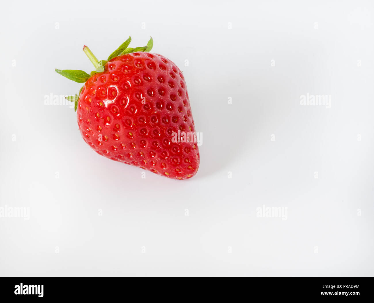 single fresh red strawberry on a light background Stock Photo - Alamy