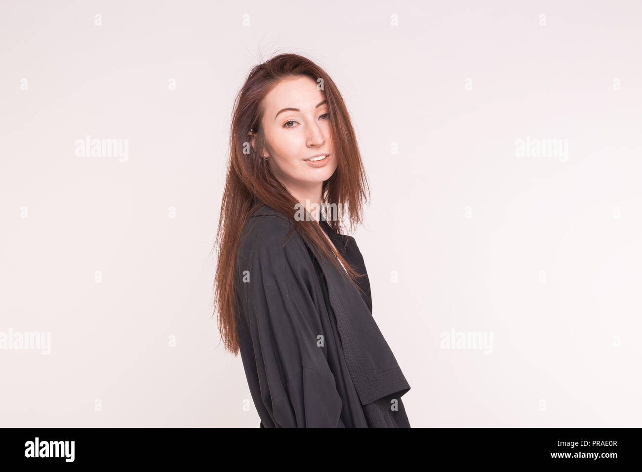 Young asian woman in black coat on white background with copy space ...