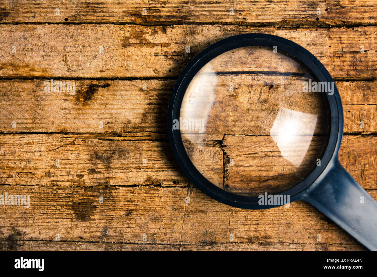 Magnifying glass on rustic wooden background top view Stock Photo - Alamy