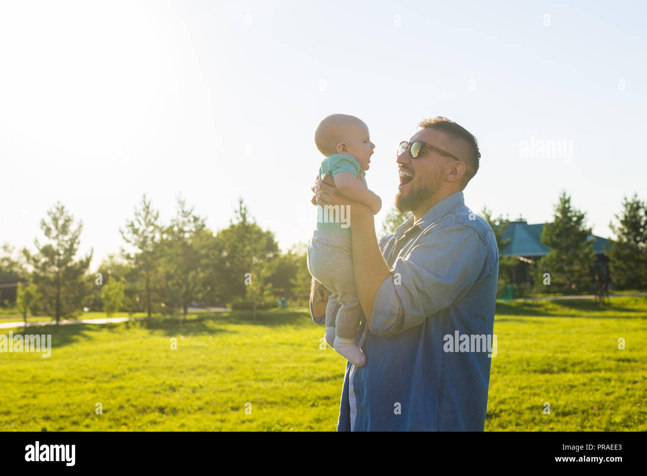 Happy father holding baby son on nature. Concept of happy family ...
