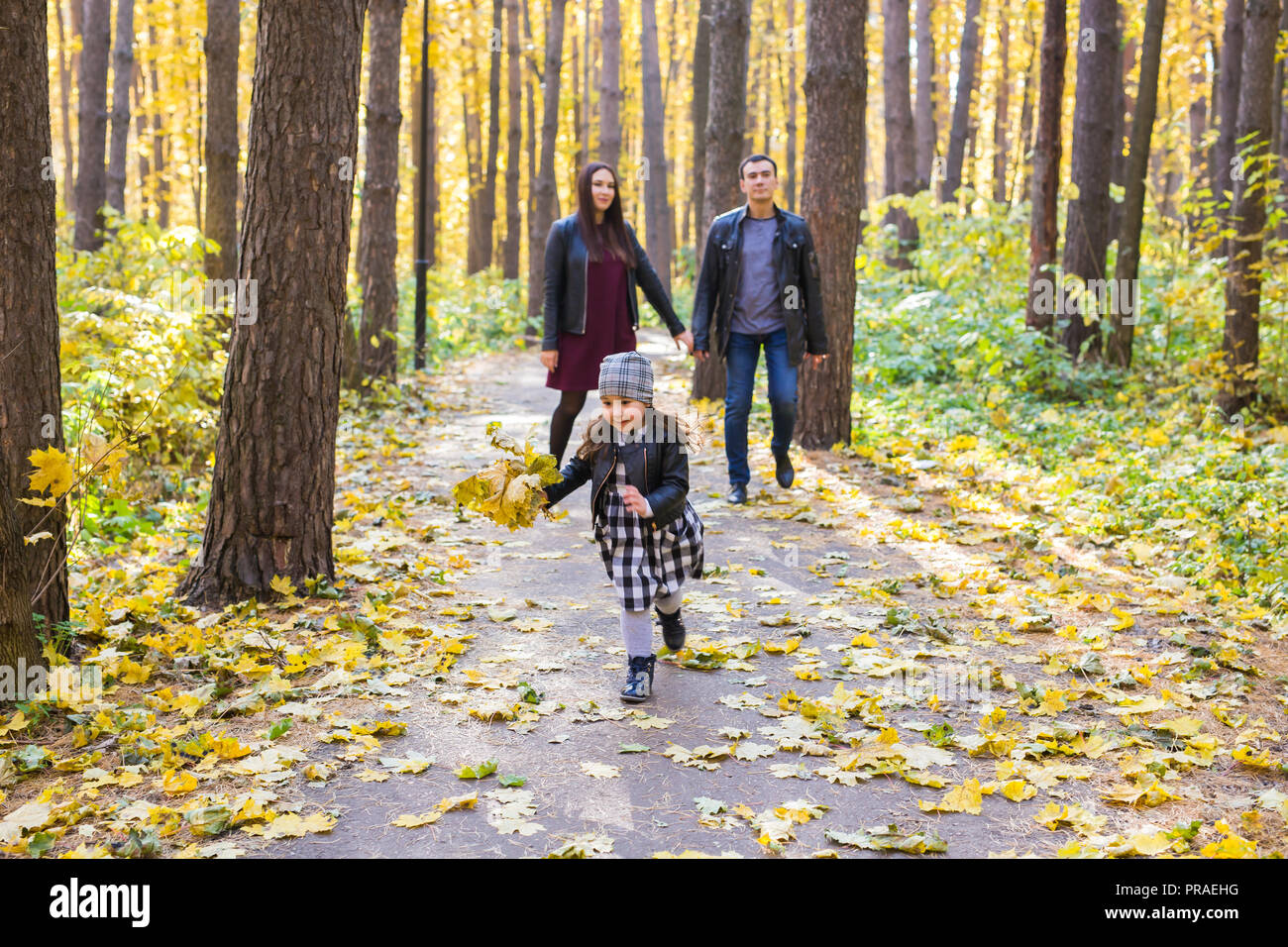Fall, nature and family concept - happy family walking in autumn park ...
