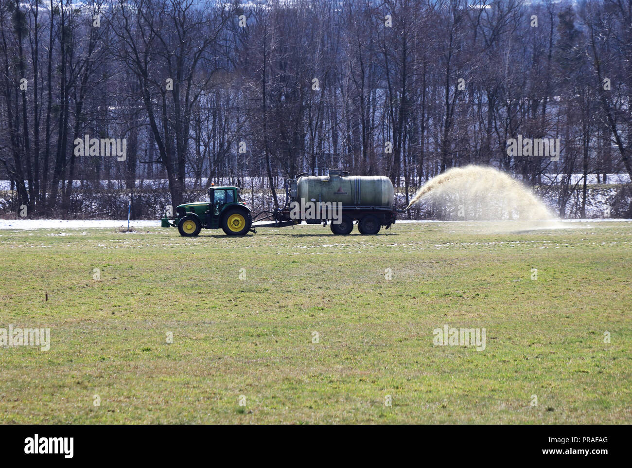 A tractor pouring the field with liquid manure for better structure of ...
