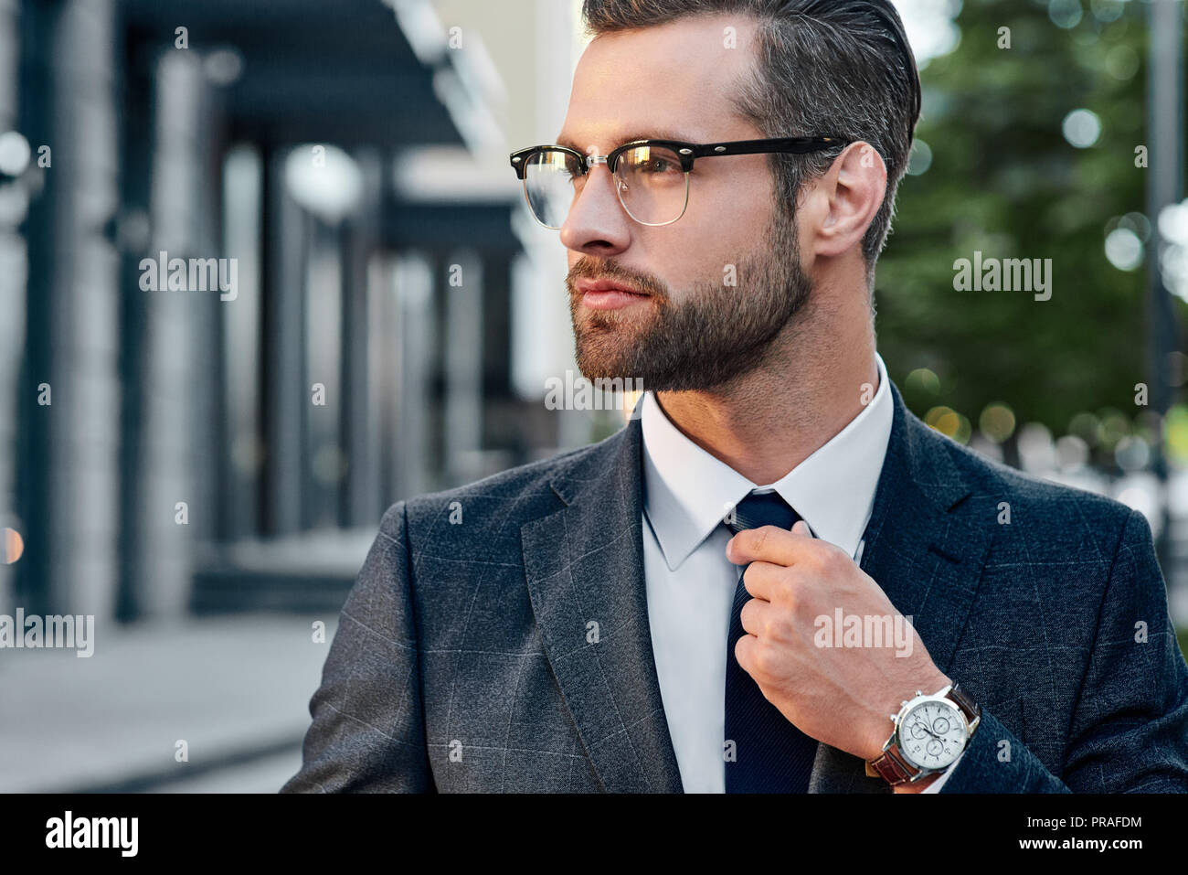 The young in spectacles men straightens his tie, his face unshaven ...