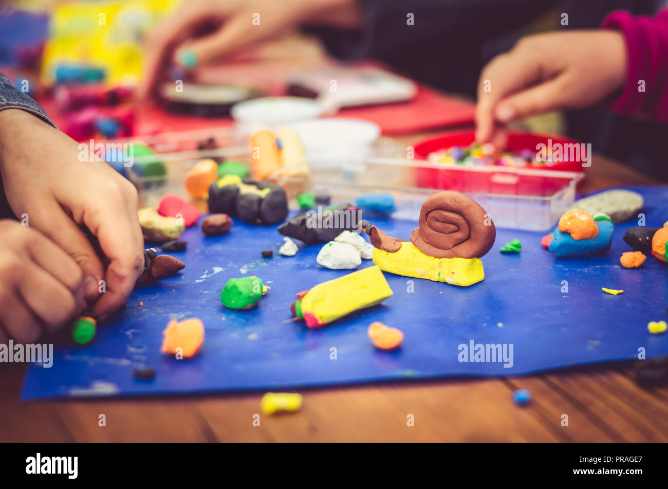 kids playing with play dough on the table and creating a snail animal ...