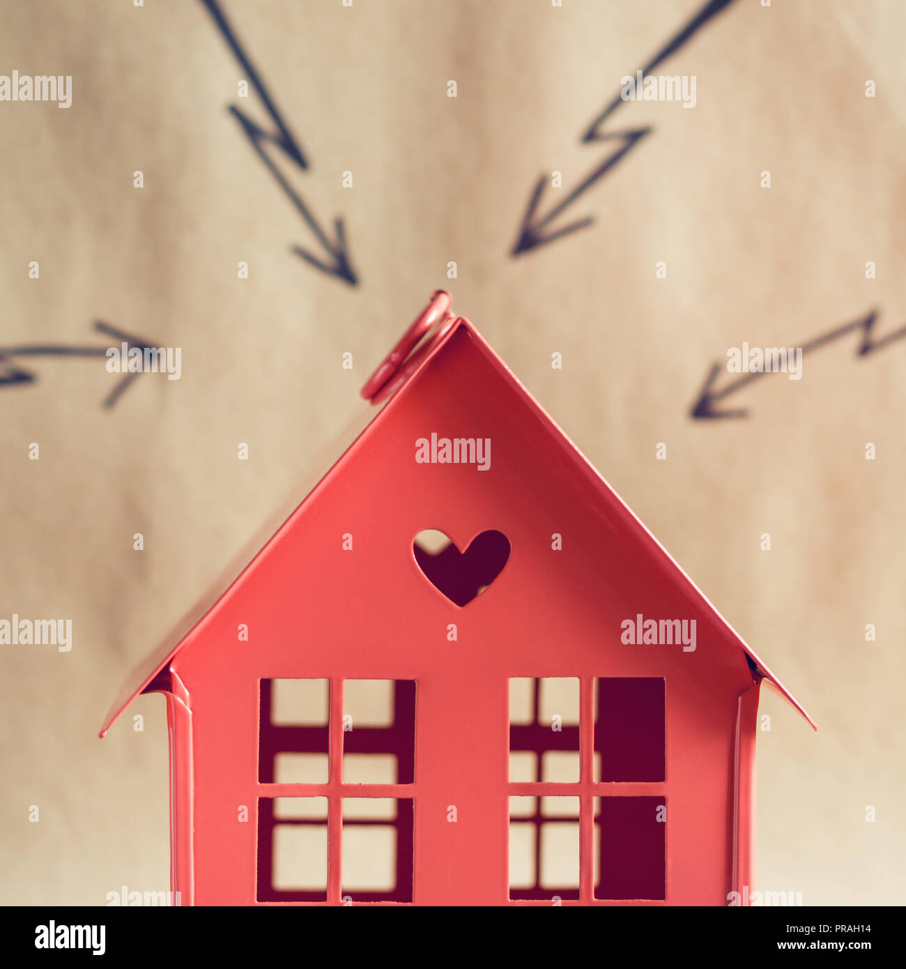 Metal red model of a house with a heart. The concept of protecting a ...