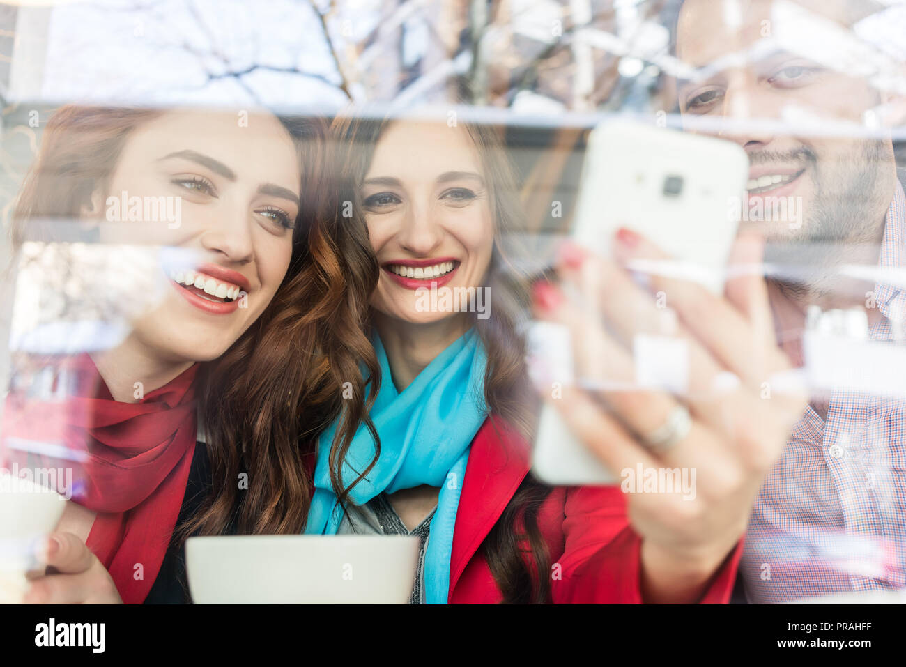 Fashionable young woman showing to her best friends pictures on the ...
