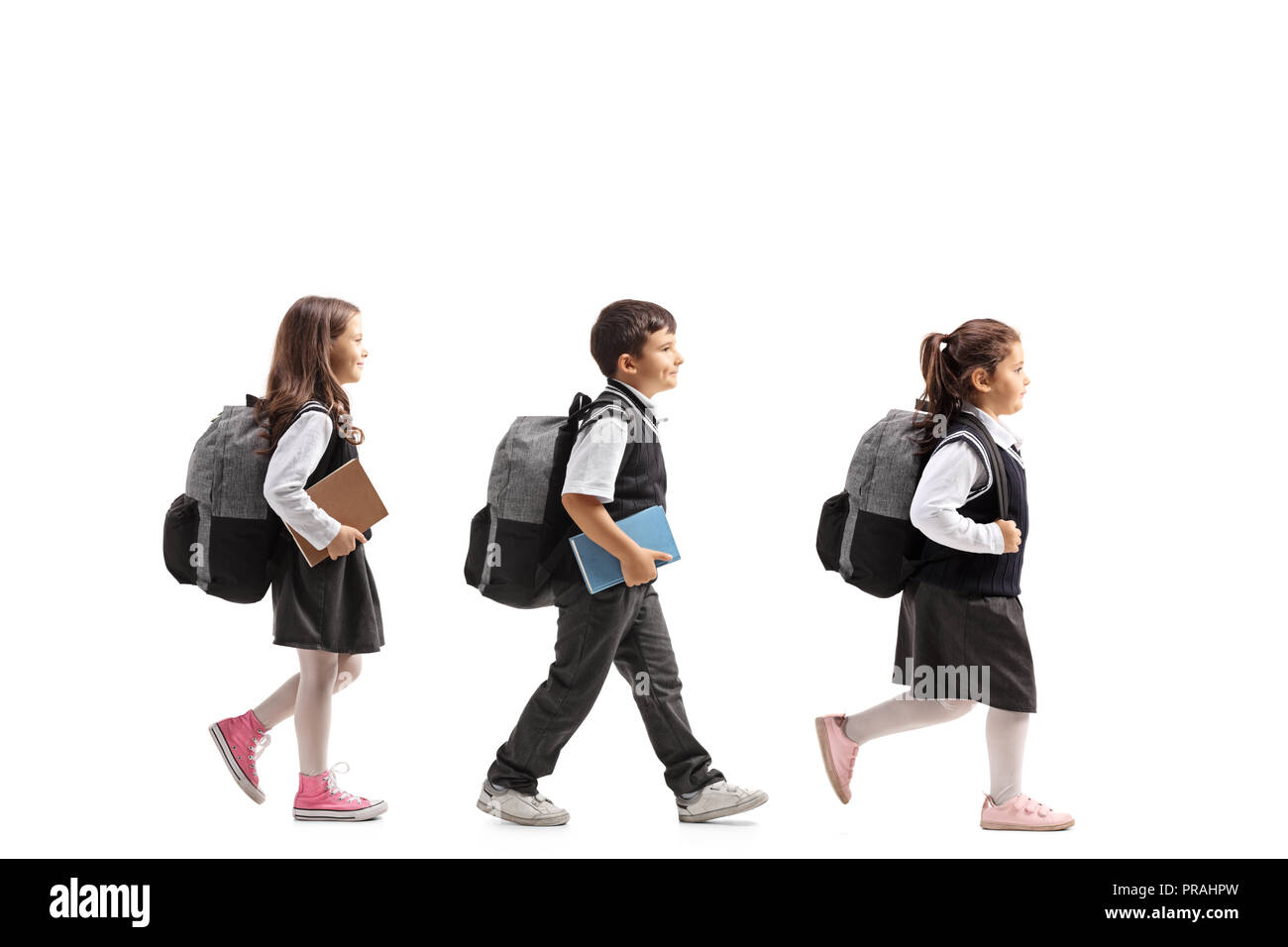 Full length profile shot of schoolchildren walking isolated on white ...
