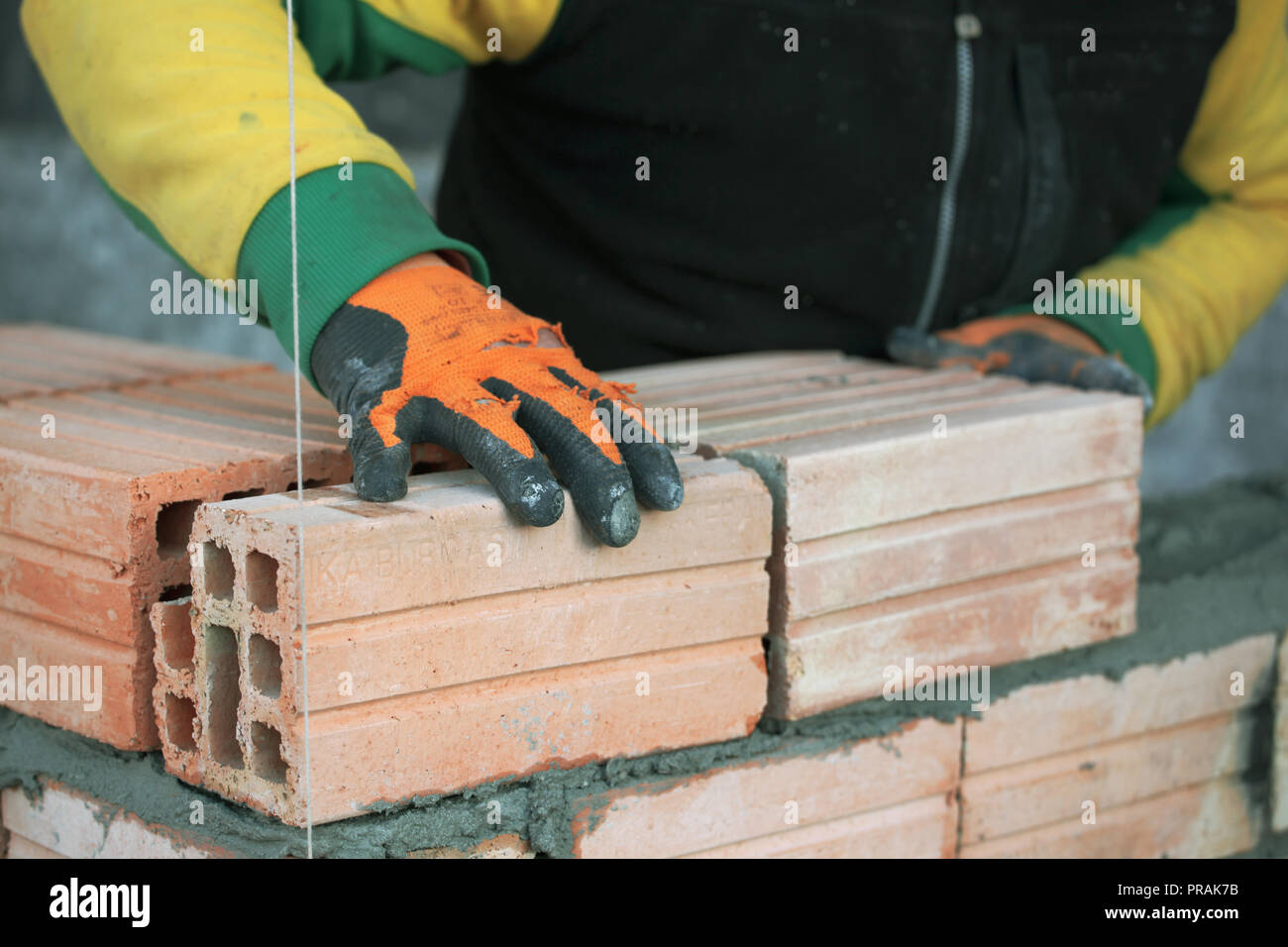 Industrial bricklayer installing bricks on construction site Stock ...