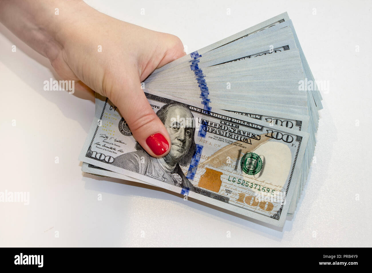 Stack of one hundred dollar banknotes in hand Stock Photo - Alamy