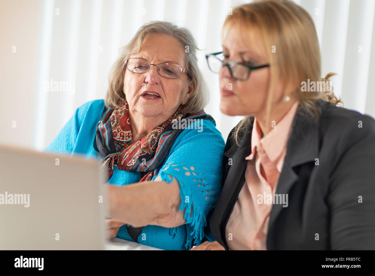 Woman Helping Senior Adult Lady on Laptop Computer Stock Photo - Alamy