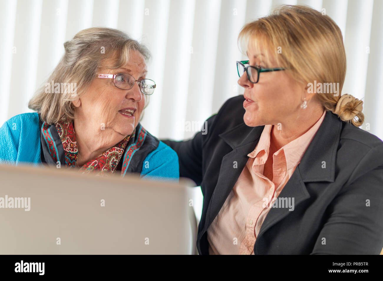 Woman Helping Senior Adult Lady on Laptop Computer Stock Photo - Alamy